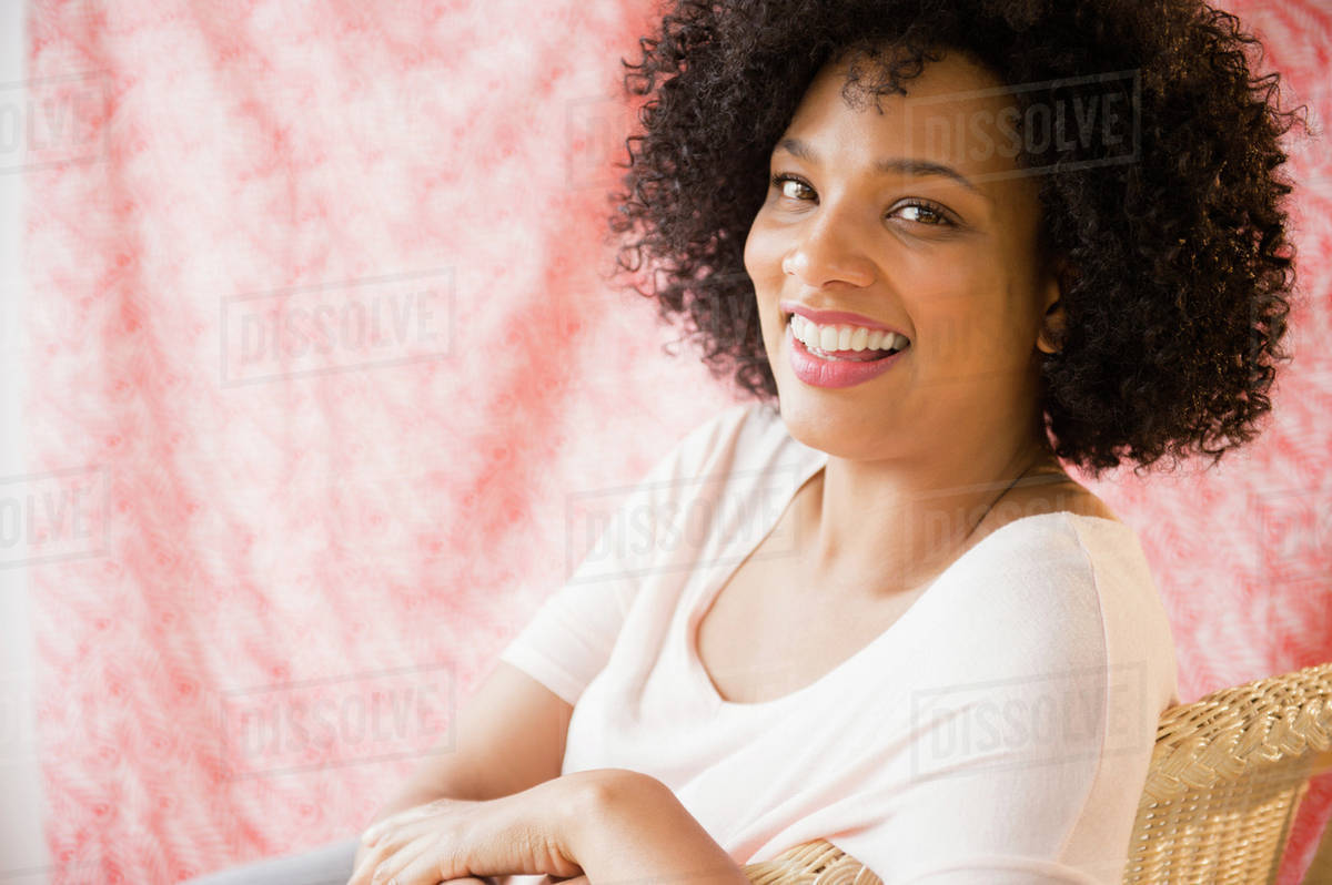 Smiling woman sitting in chair - Royalty-free Stock Photo | Dissolve