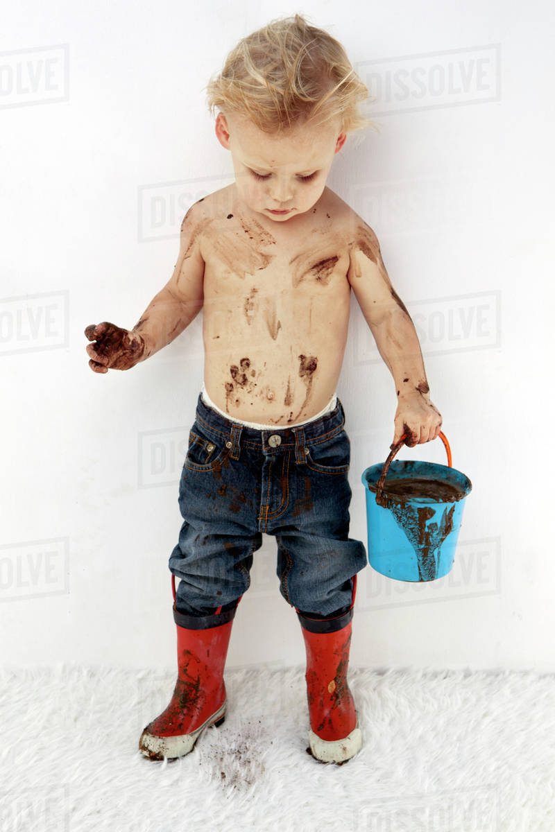 Messy Caucasian boy playing with mud on white carpet - Royalty-free ...