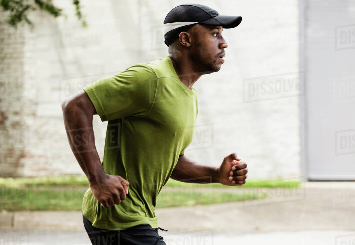 Black man running on city street - Royalty-free Stock Photo | Dissolve