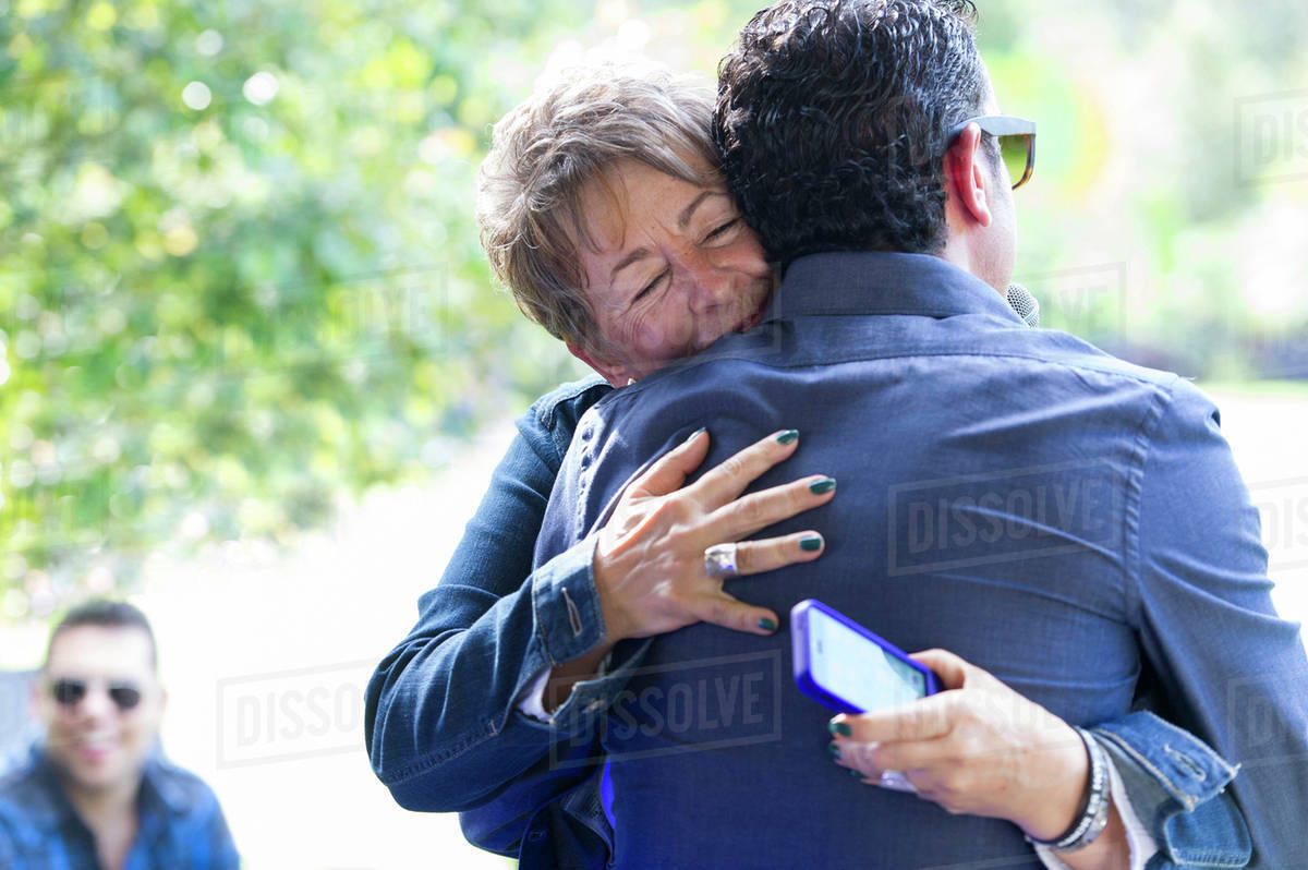 Family members hugging at reunion - Stock Photo - Dissolve