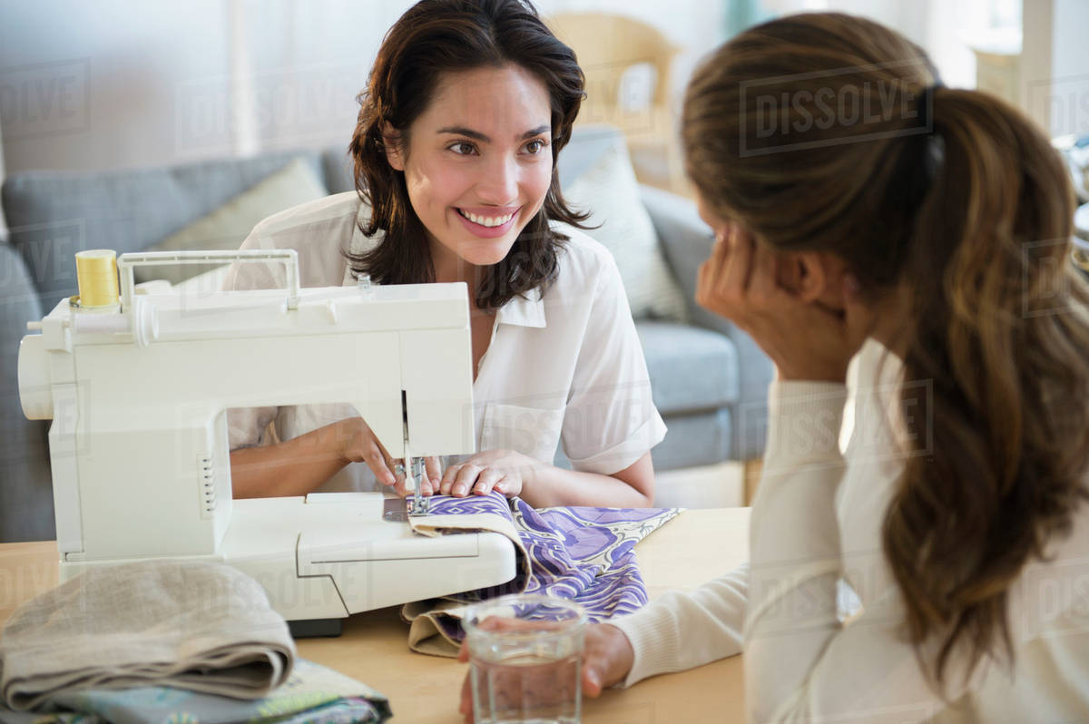 Hispanic women using sewing machine in living room - Royalty-free Stock ...