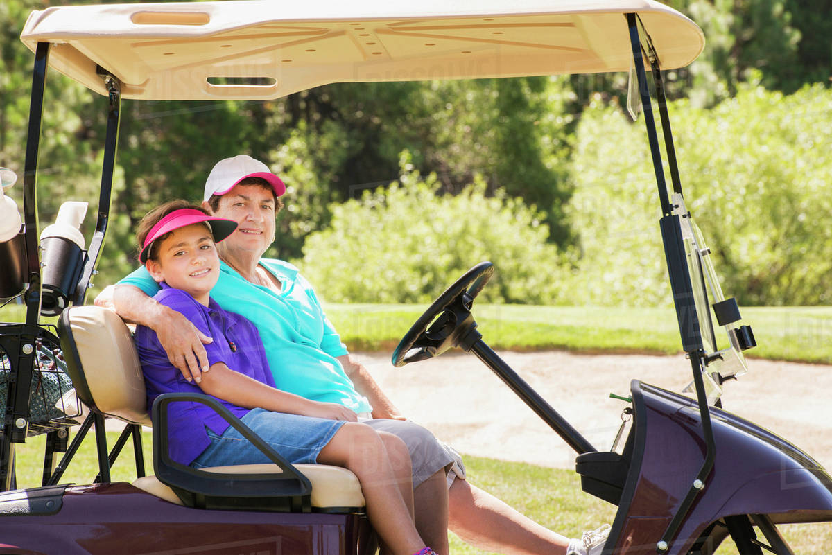 Grandmother and grandson driving golf cart on course - Royalty-free ...