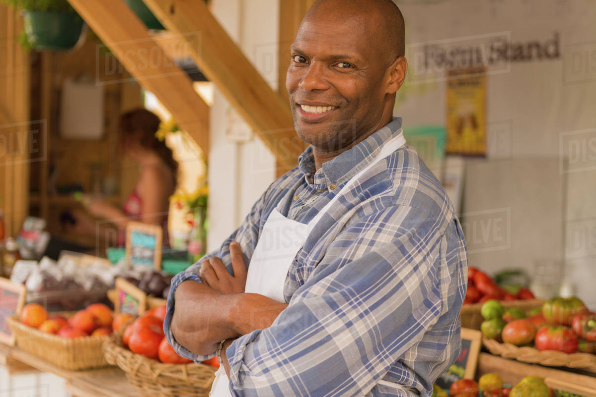 African American vendor smiling at farmers market - Stock Photo - Dissolve