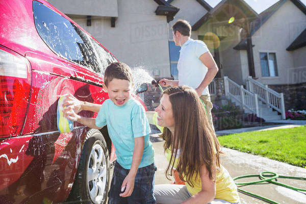 Caucasian family washing car in driveway - Royalty-free Stock Photo ...