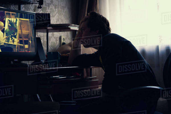 Caucasian man watching computer screen at desk - Royalty-free Stock ...