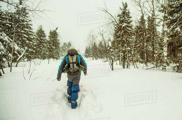 Caucasian hiker walking in deep snow - Royalty-free Stock Photo | Dissolve