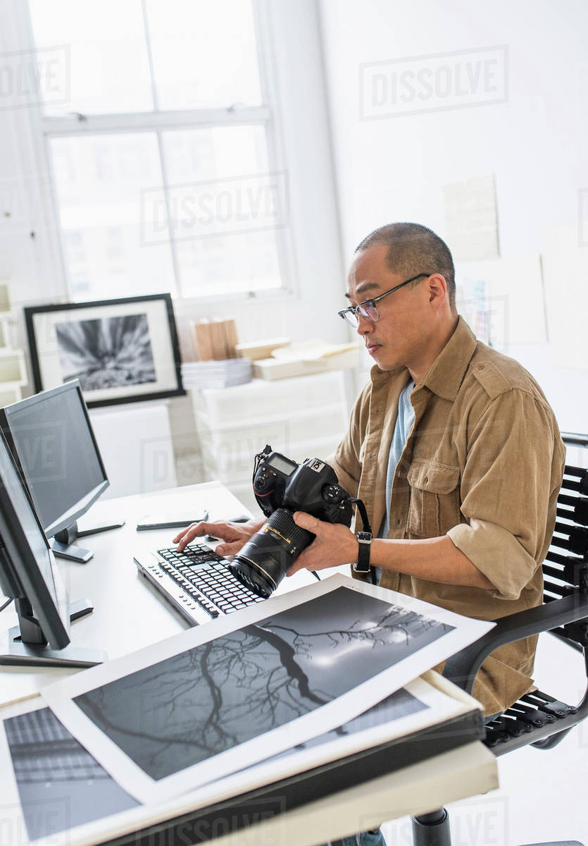 Korean photographer using computer at desk - Royalty-free Stock Photo ...