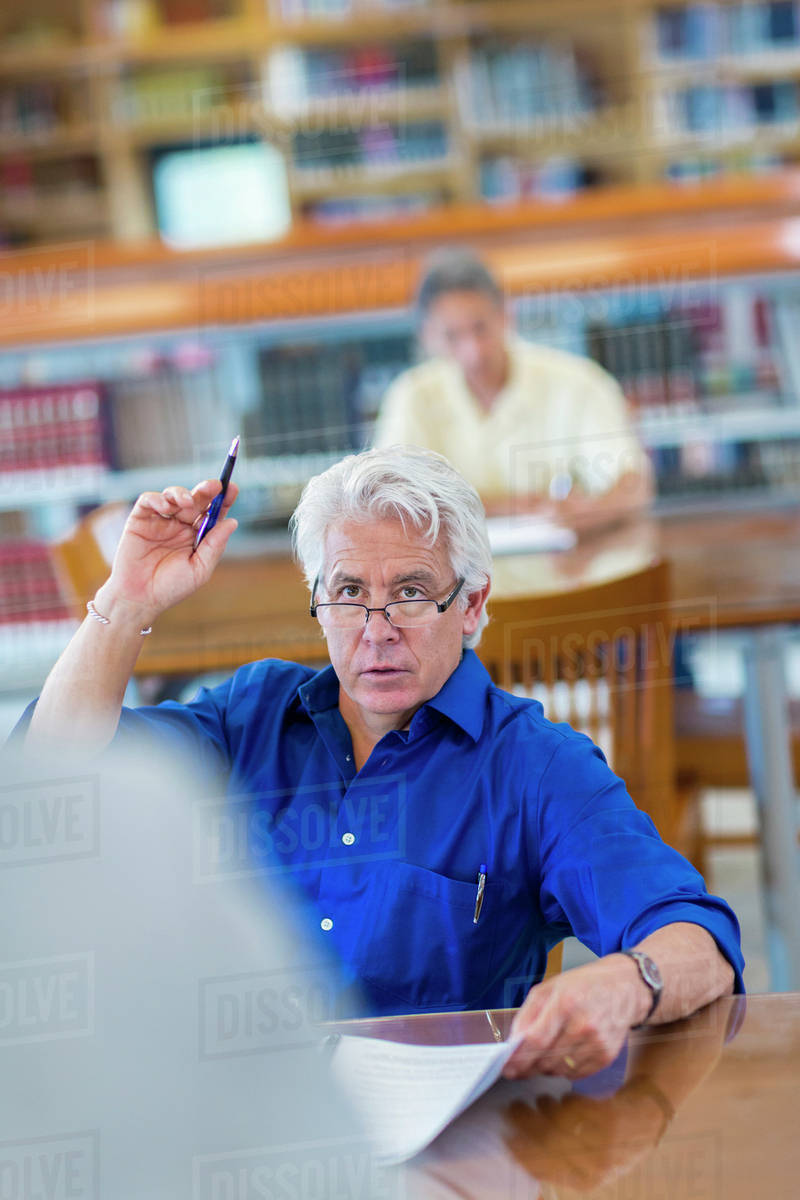 Adult student raising his hand in class - Stock Photo - Dissolve