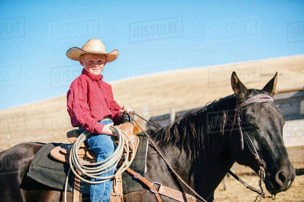 Caucasian boy riding horse on ranch - Royalty-free Stock Photo | Dissolve