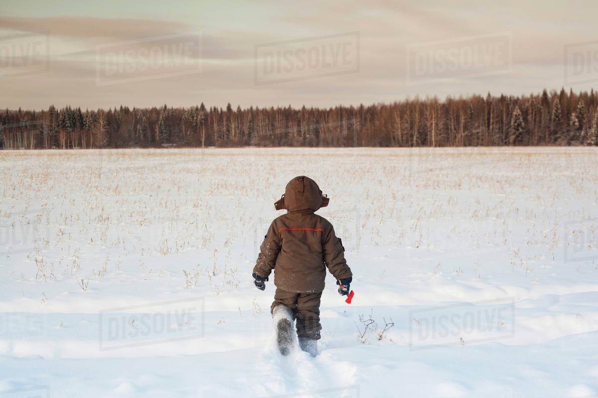 Mari boy walking in snowy field - Royalty-free Stock Photo | Dissolve