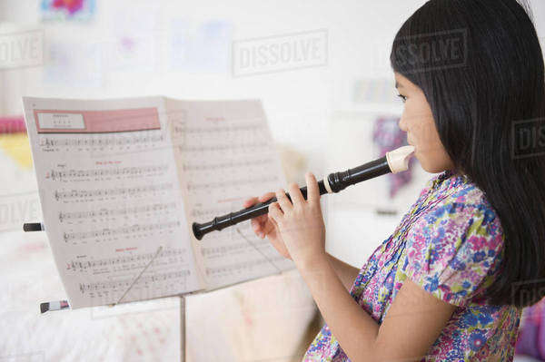 Vietnamese girl playing recorder from sheet music - Royalty-free Stock ...
