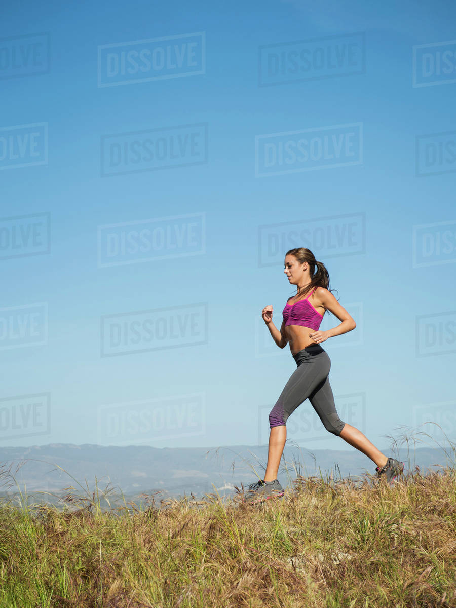 Mixed race woman running in rural landscape - Royalty-free Stock Photo ...