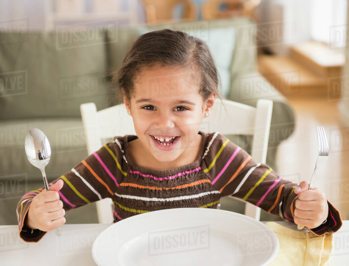 Hispanic girl demanding food at table - Royalty-free Stock Photo | Dissolve