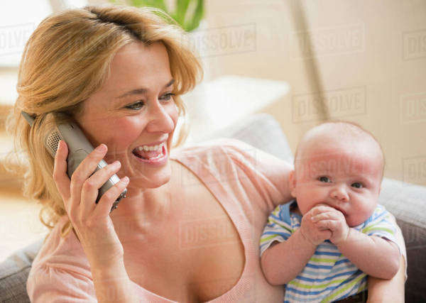 Caucasian mother with baby talking on telephone - Royalty-free Stock ...