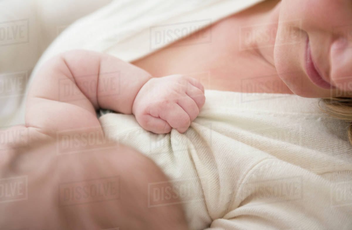 Caucasian baby gripping mother's sweater - Royalty-free Stock Photo ...