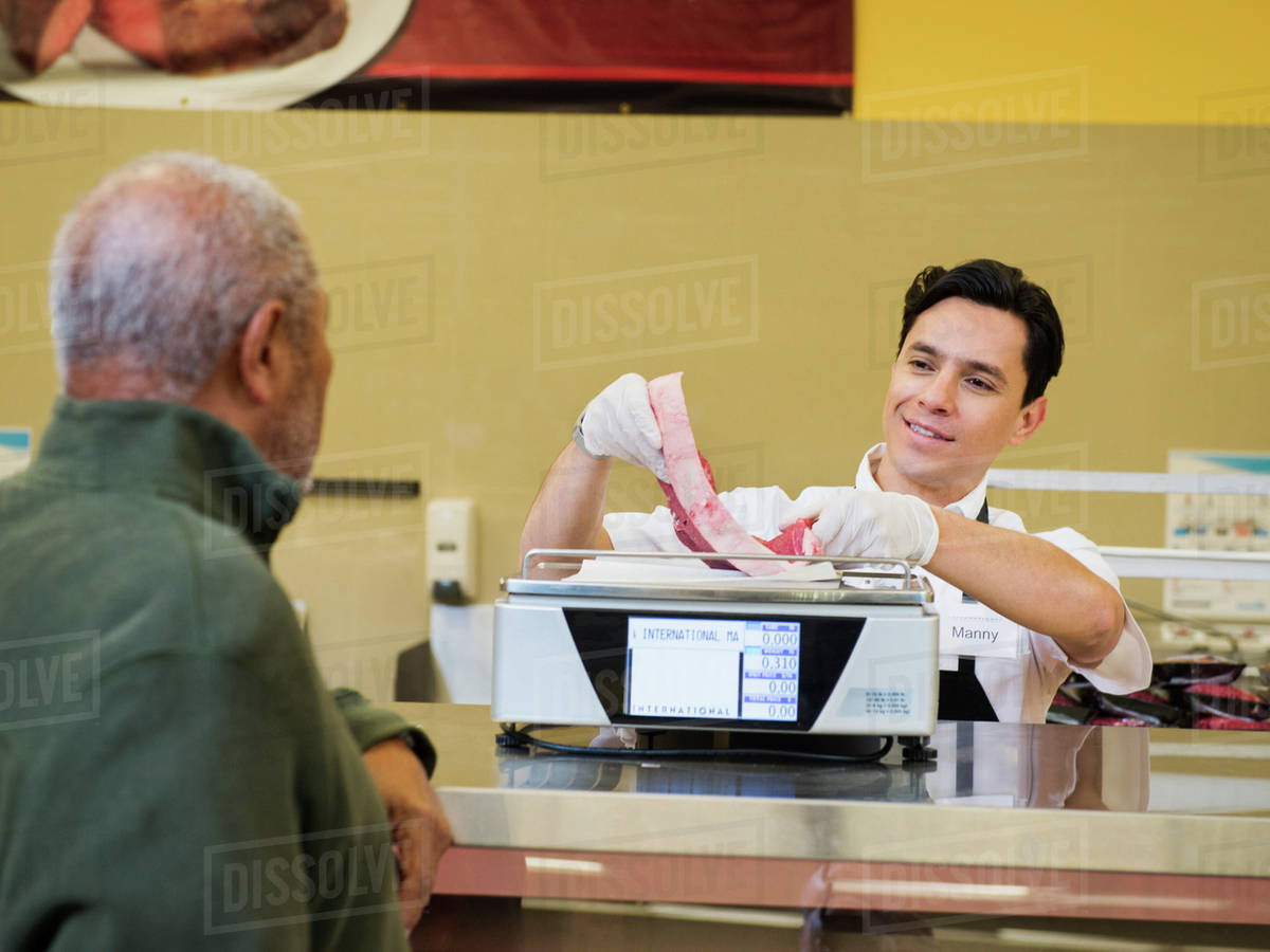 Butcher serving customer meat counter of grocery store - Royalty-free ...