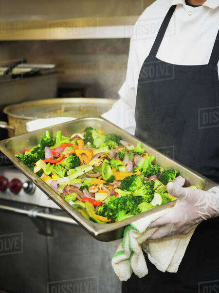 Hispanic chef with tray of vegetables in kitchen - Royalty-free Stock ...