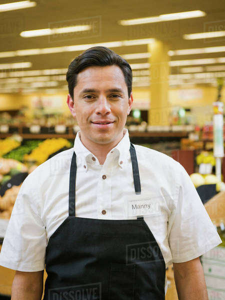 Hispanic worker smiling in grocery store - Royalty-free Stock Photo ...