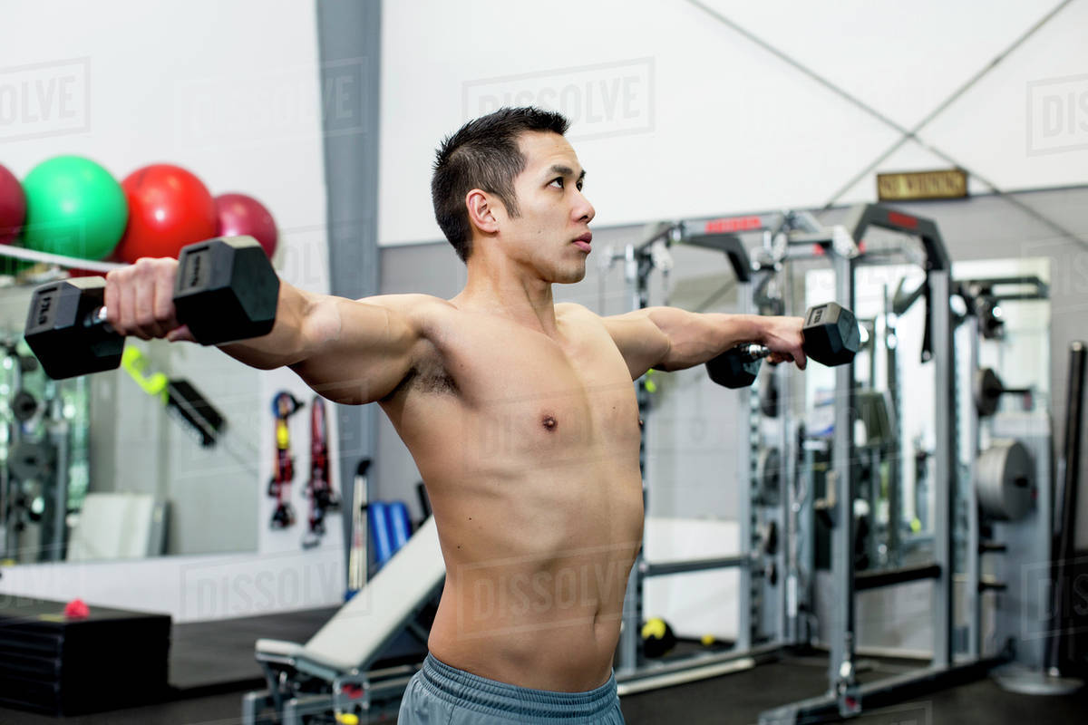 Pacific Islander man lifting weights in gym - Royalty-free Stock Photo ...