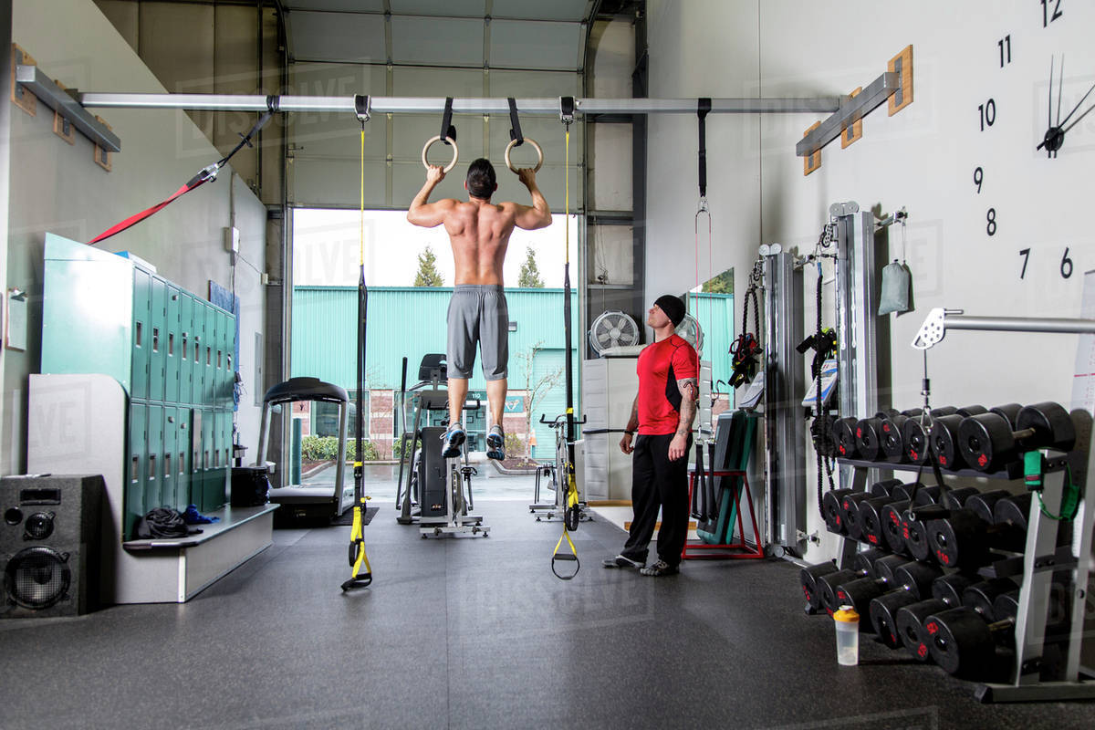 Man working with trainer in gym - Royalty-free Stock Photo | Dissolve