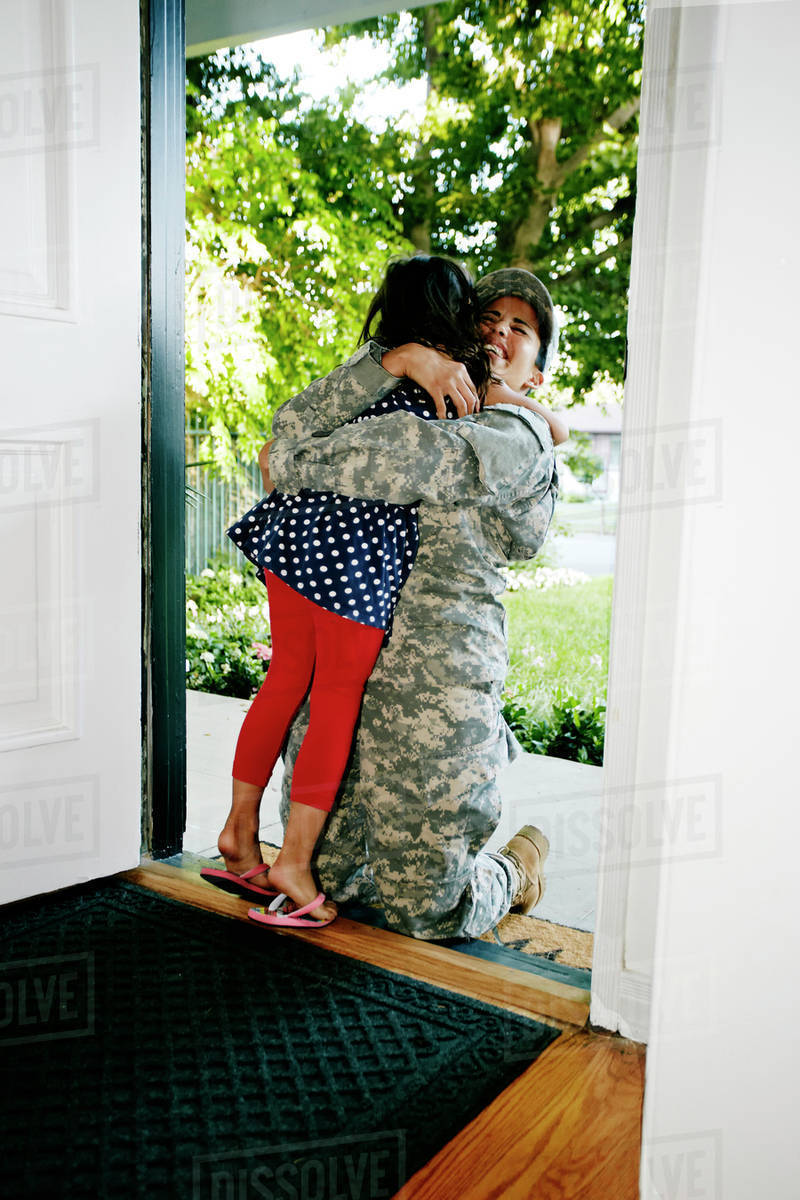 Mixed race soldier mother hugging daughter in front door - Stock Photo ...