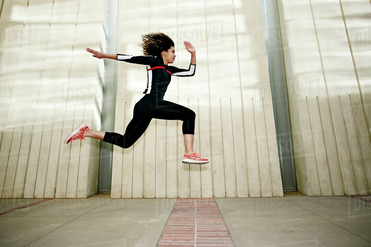 Mixed race woman running on city street - Royalty-free Stock Photo ...