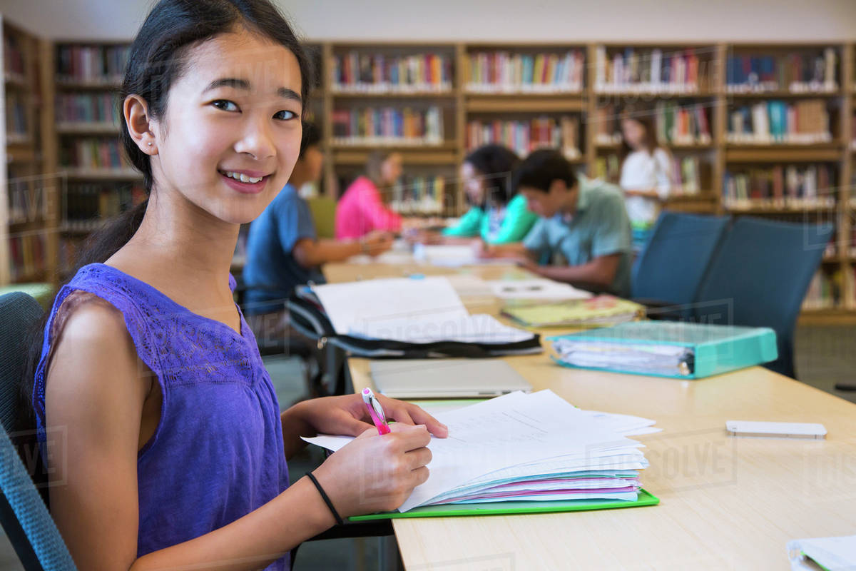 Student taking notes in library - Royalty-free Stock Photo | Dissolve