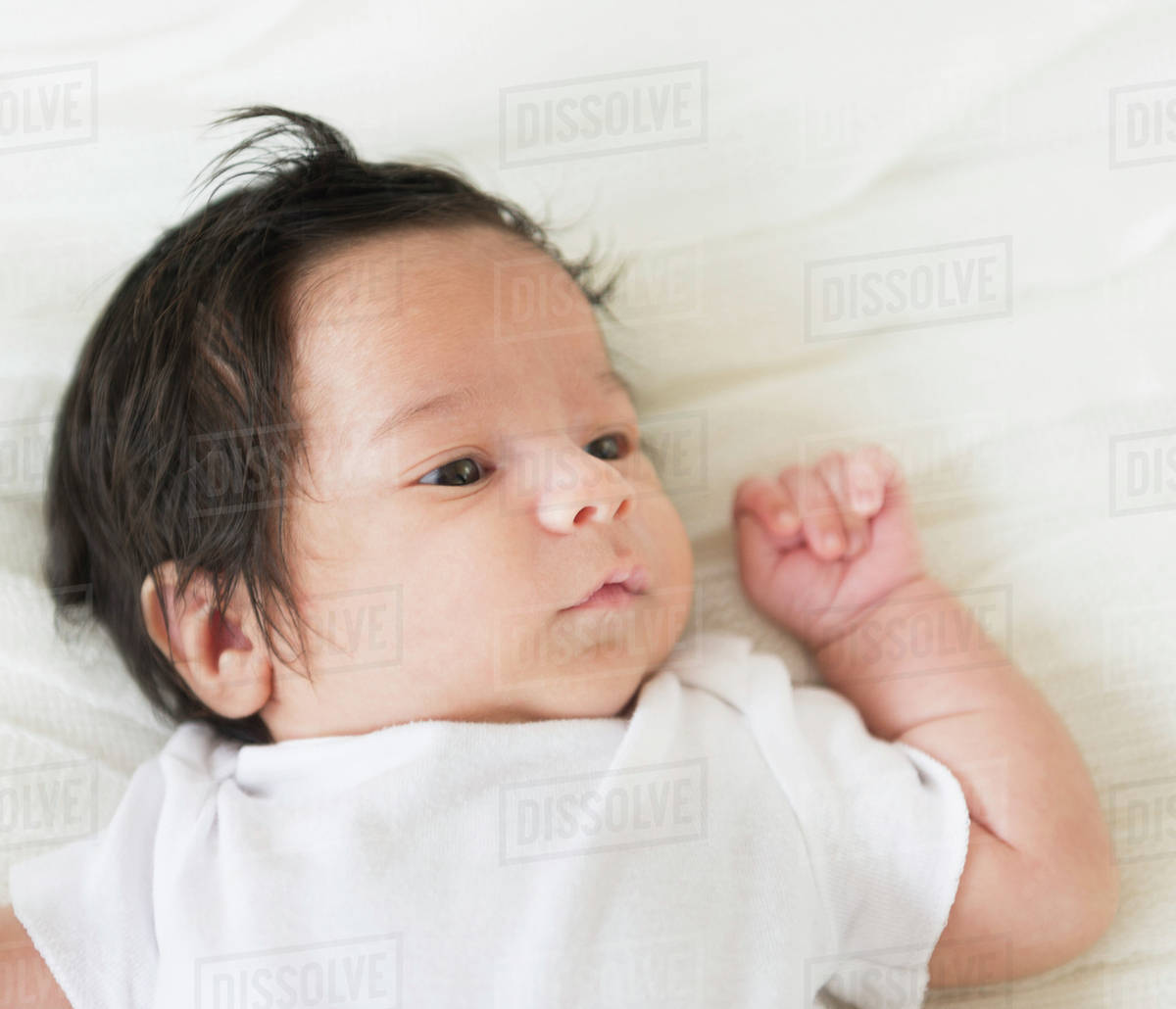 Hispanic infant laying on blanket - Royalty-free Stock Photo | Dissolve