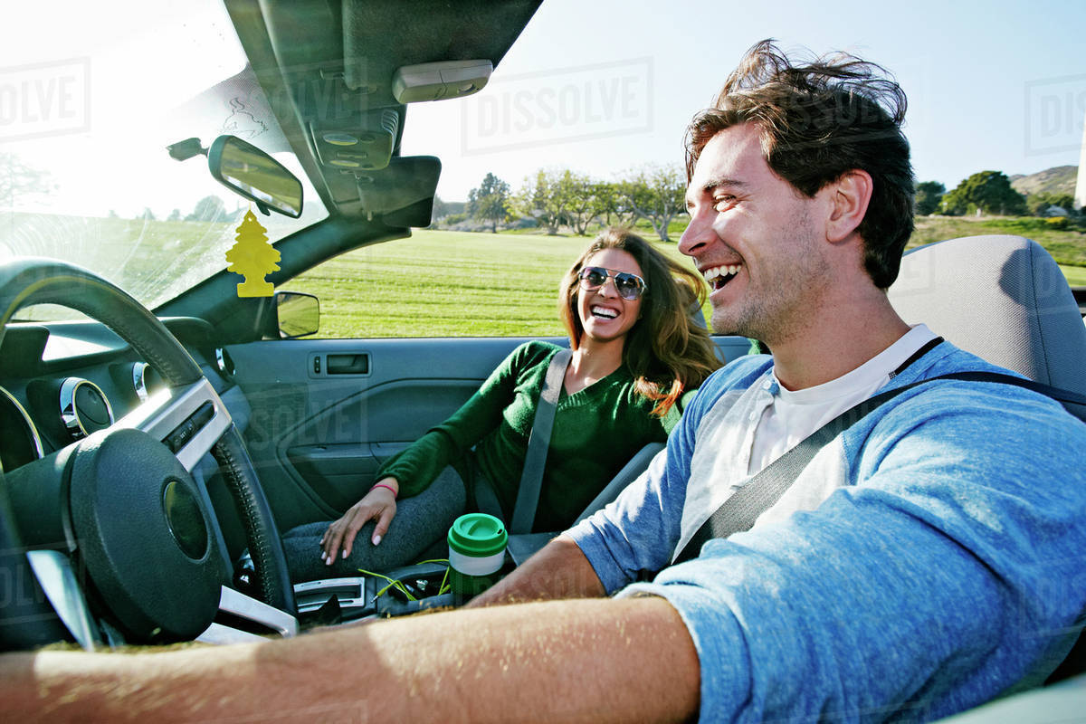 Couple driving in convertible - Stock Photo - Dissolve