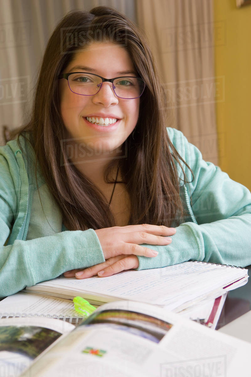 Hispanic girl doing homework at table - Royalty-free Stock Photo | Dissolve
