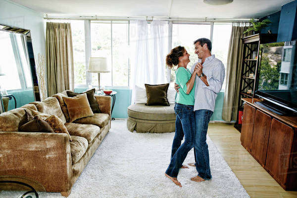 Caucasian couple dancing in living room - Royalty-free Stock Photo ...