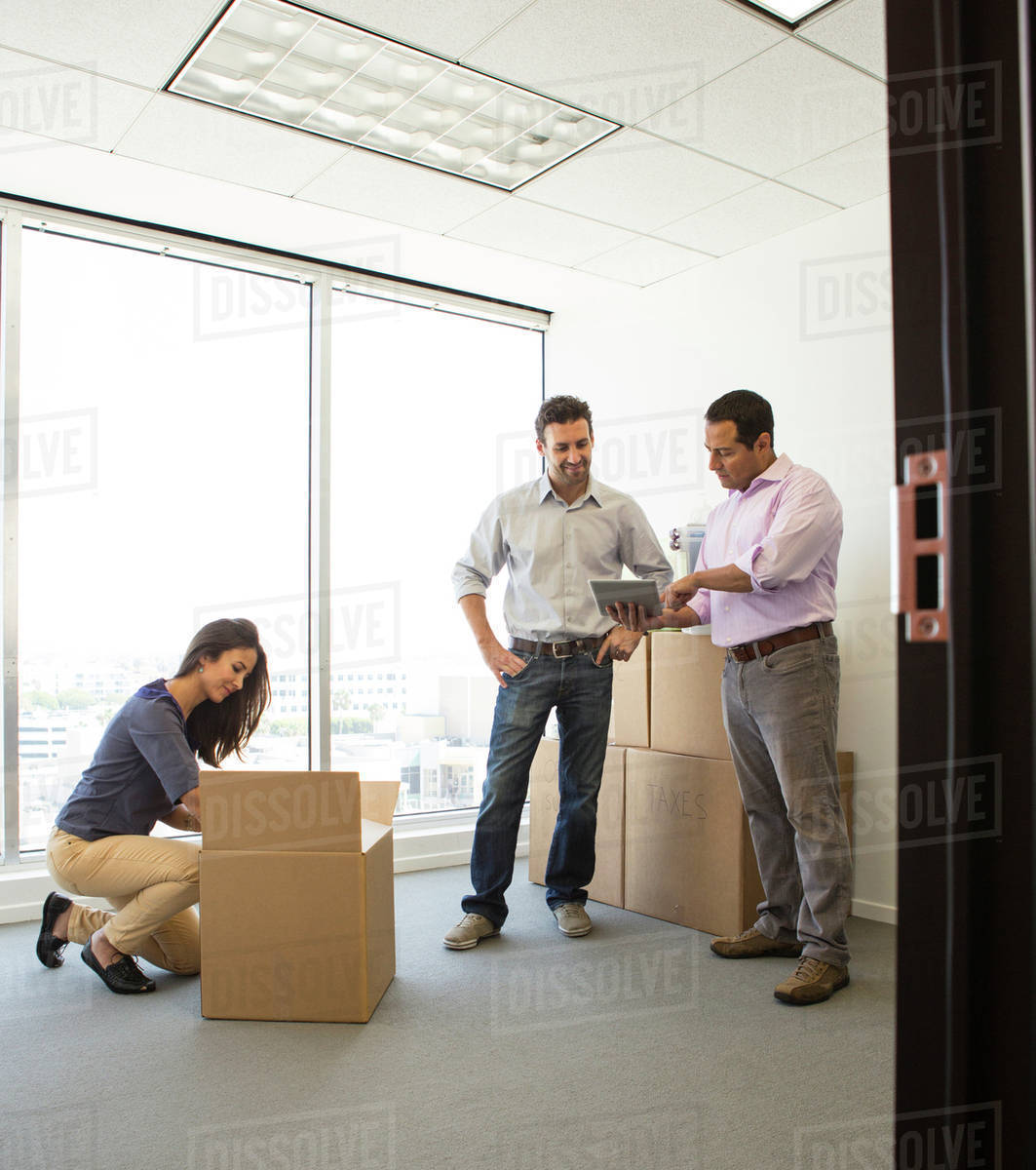 Business people unpacking in new office - Stock Photo - Dissolve