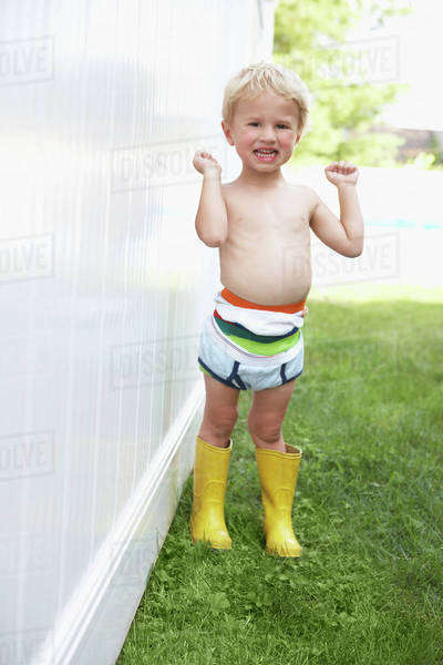 Caucasian boy wearing diaper and rain boots outdoors - Royalty-free ...