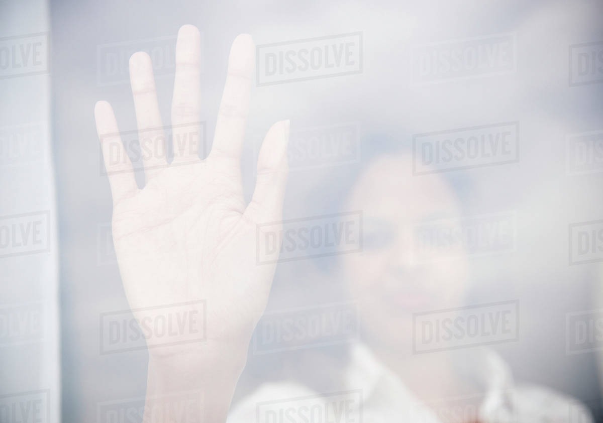 Cape Verdean woman putting hand on window - Stock Photo - Dissolve