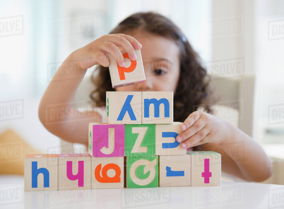 Mixed race girl stacking blocks - Royalty-free Stock Photo | Dissolve