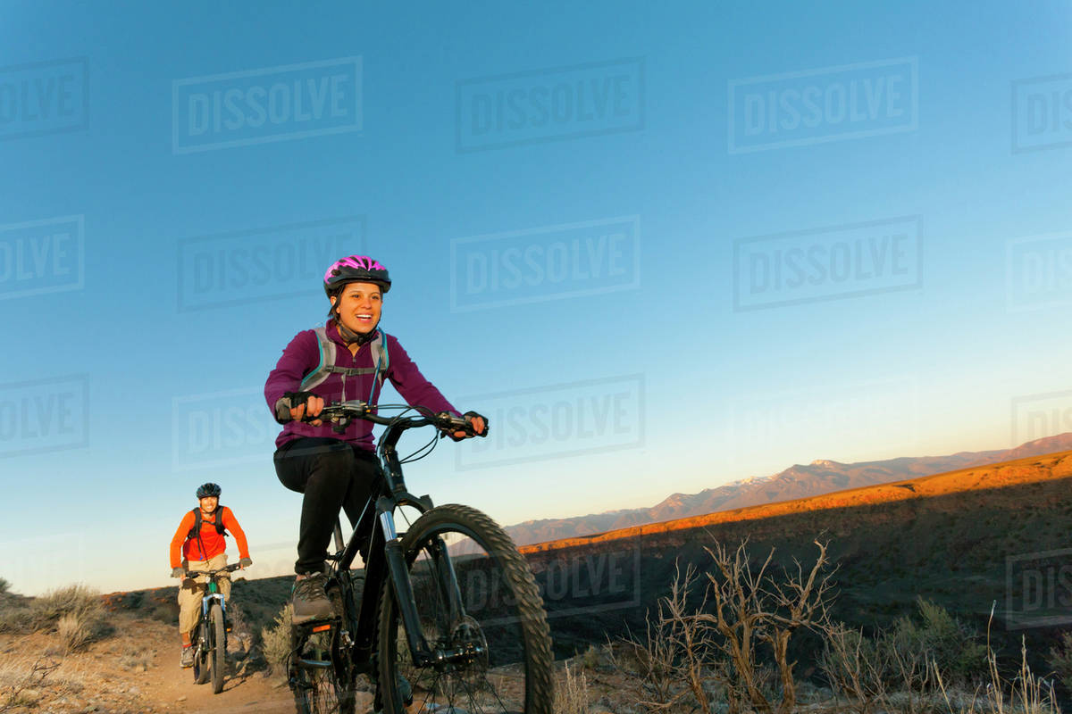 Couple mountain biking together - Royalty-free Stock Photo | Dissolve