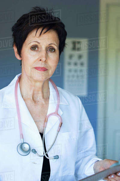 Caucasian doctor holding clipboard in office - Royalty-free Stock Photo ...