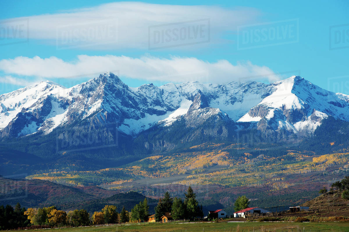 Snowy mountains overlooking rural landscape - Stock Photo - Dissolve
