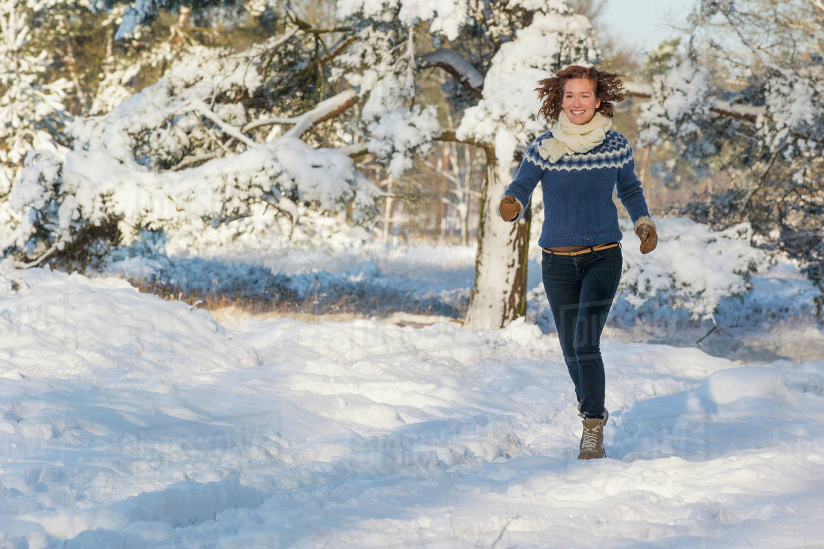 Caucasian woman walking in snow - Royalty-free Stock Photo | Dissolve