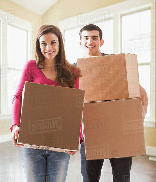 Couple carrying cardboard boxes in new home - Royalty-free Stock Photo ...