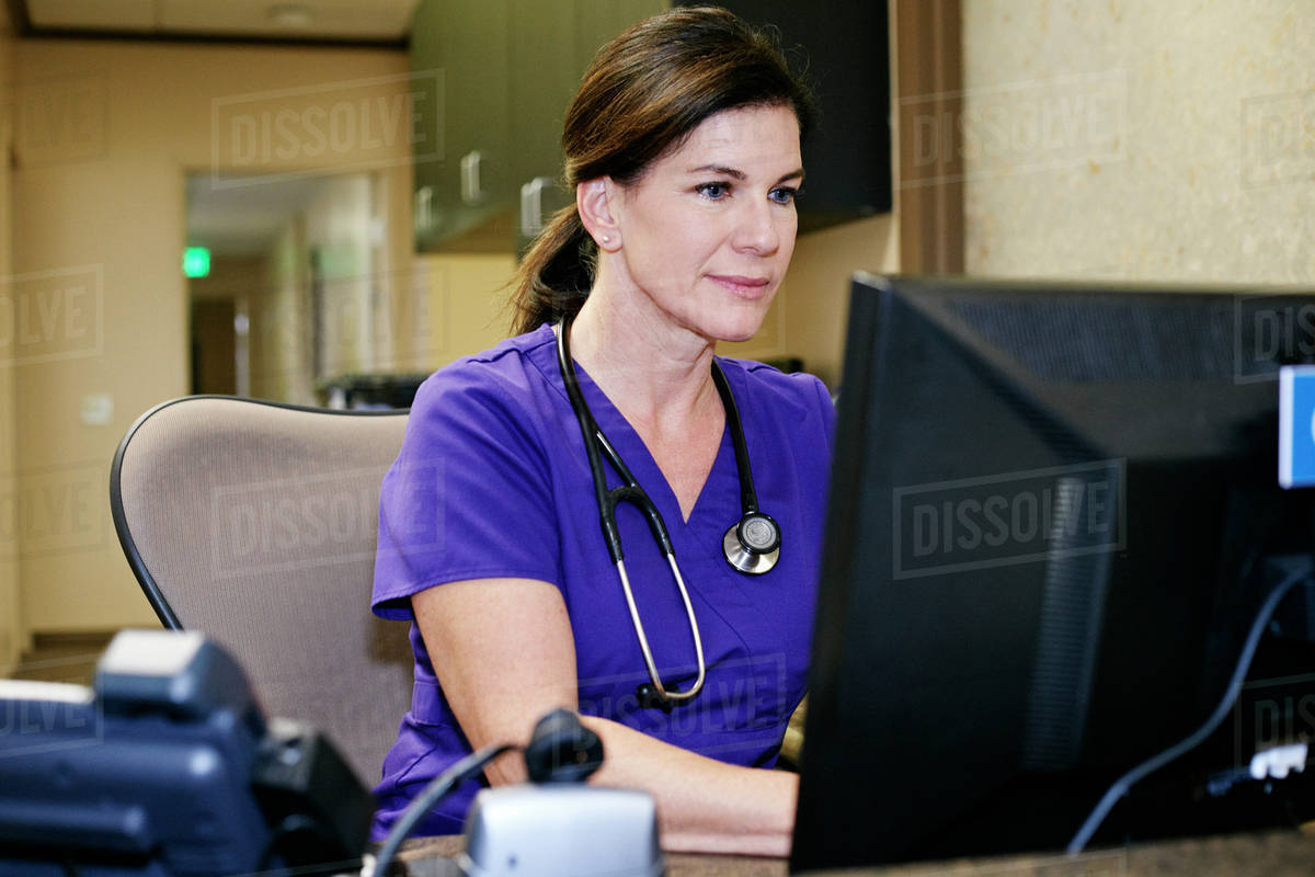 Caucasian nurse using computer in office - Royalty-free Stock Photo ...