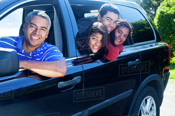 Hispanic family smiling in car - Royalty-free Stock Photo | Dissolve
