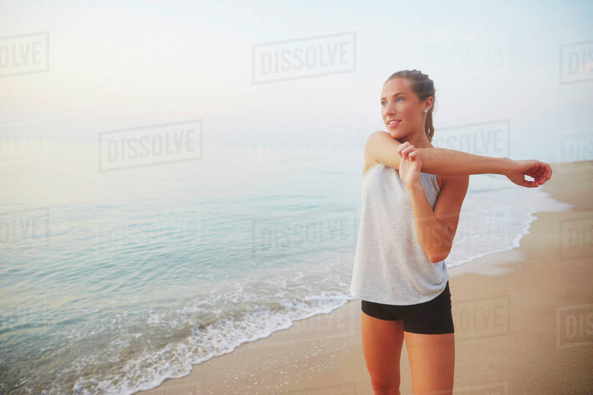 Athlete stretching on beach - Royalty-free Stock Photo | Dissolve