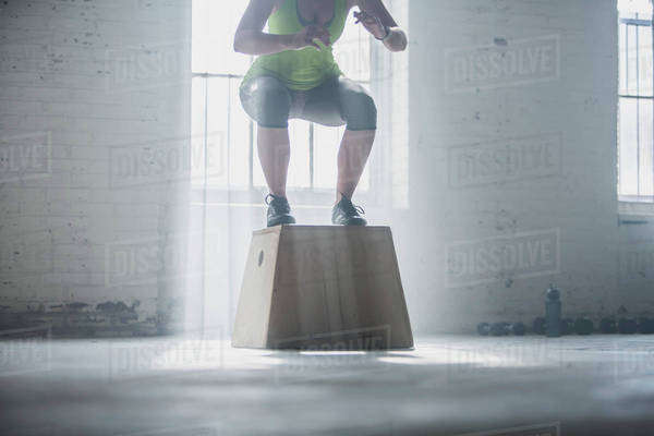 Athlete crouching on platform in gym - Royalty-free Stock Photo | Dissolve