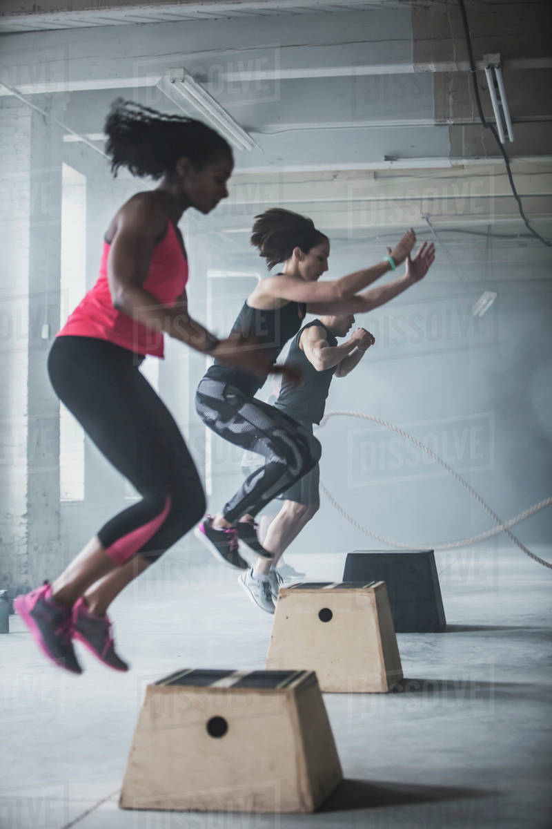 Athletes jumping on platforms in gym - Stock Photo - Dissolve