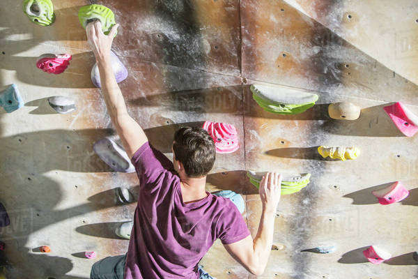 High angle view of athlete climbing rock wall in gym - Stock Photo ...