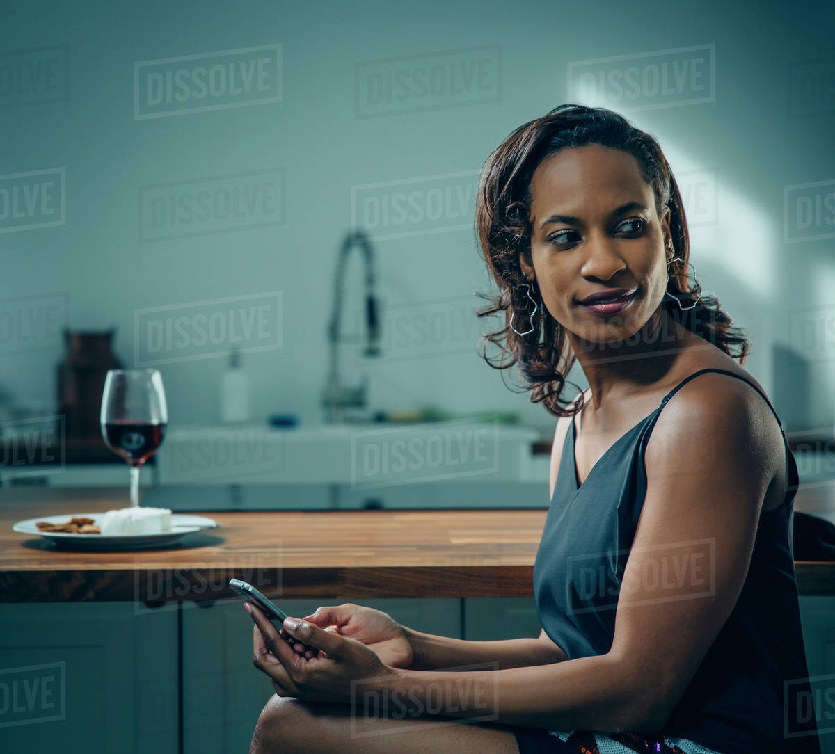 Black woman using cell phone at kitchen counter - Royalty-free Stock ...