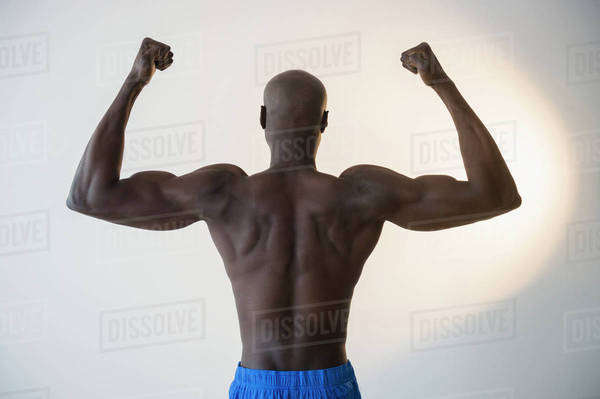 Black man flexing muscles - Stock Photo - Dissolve
