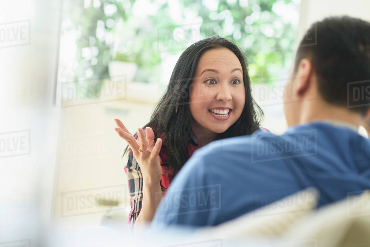 Couple talking on sofa in living room - Royalty-free Stock Photo | Dissolve