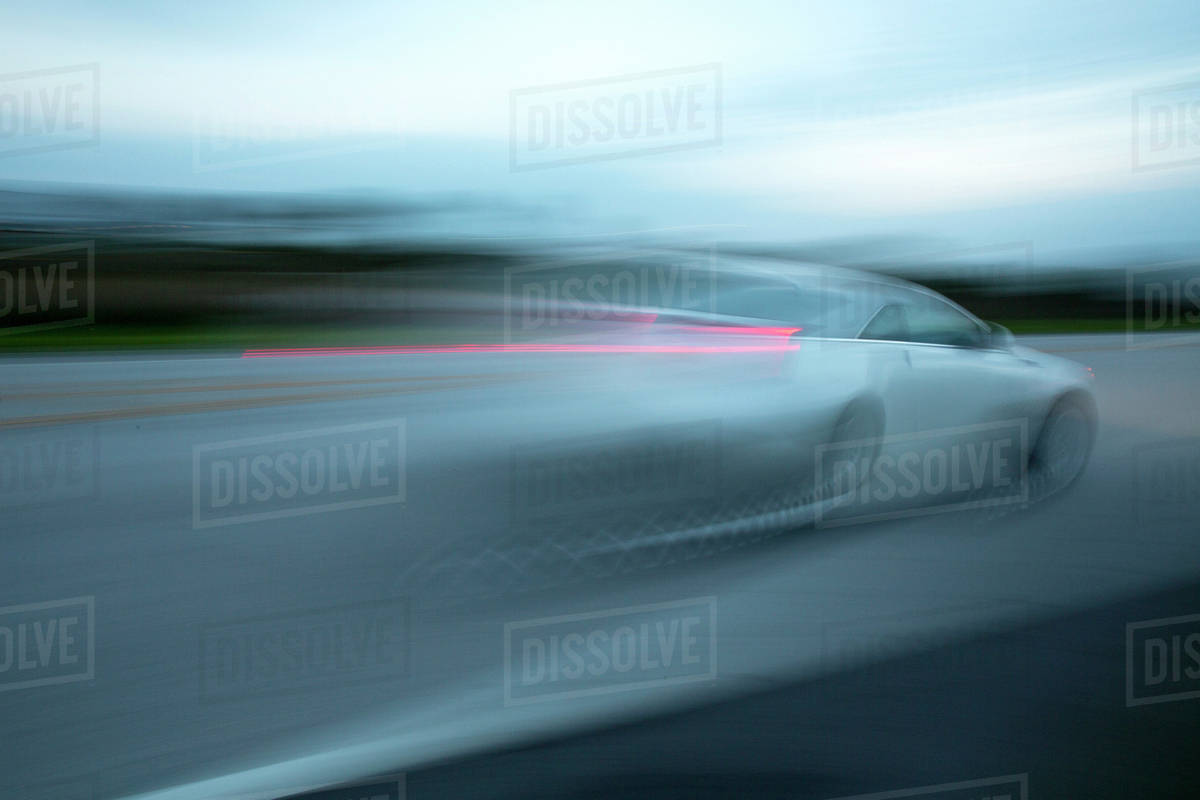 Blurred view of car driving on road - Royalty-free Stock Photo | Dissolve